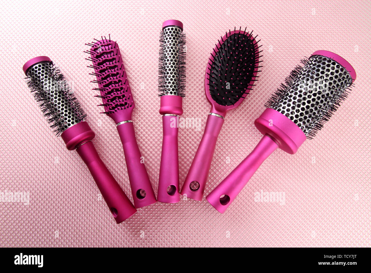 Comb brushes on pink background Stock Photo - Alamy