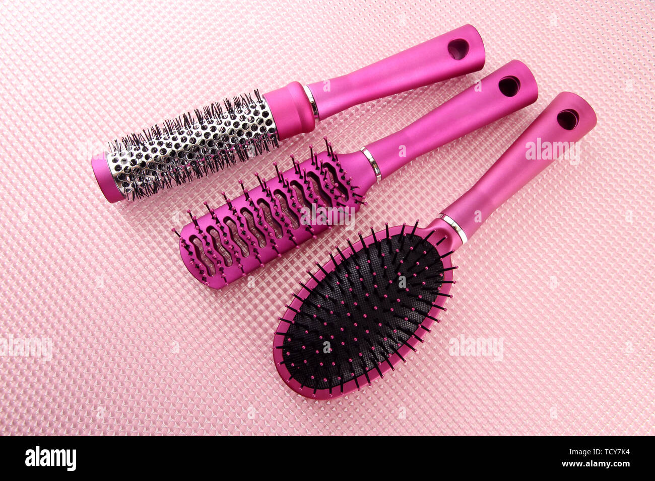 Comb brushes on pink background Stock Photo - Alamy