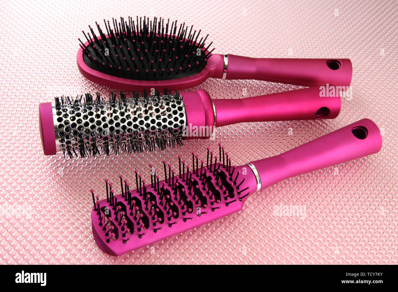 Comb brushes on pink background Stock Photo - Alamy
