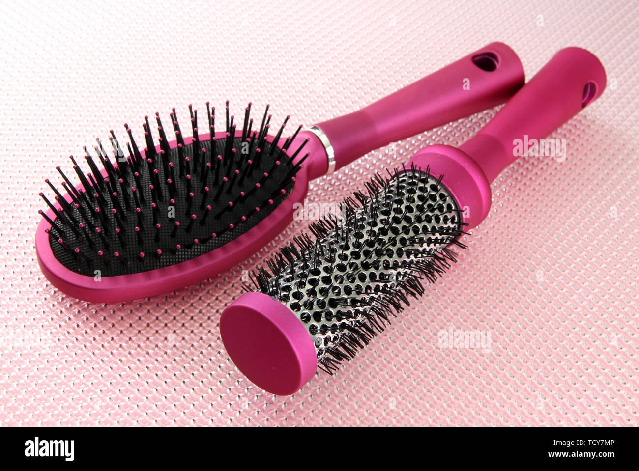 Comb brushes on pink background Stock Photo - Alamy