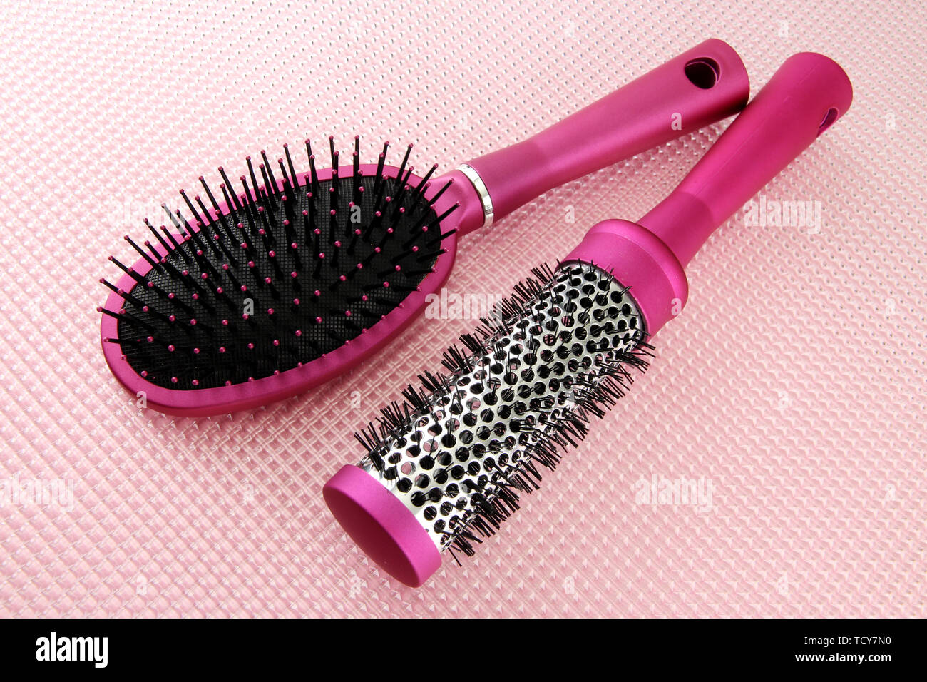 Comb brushes on pink background Stock Photo - Alamy