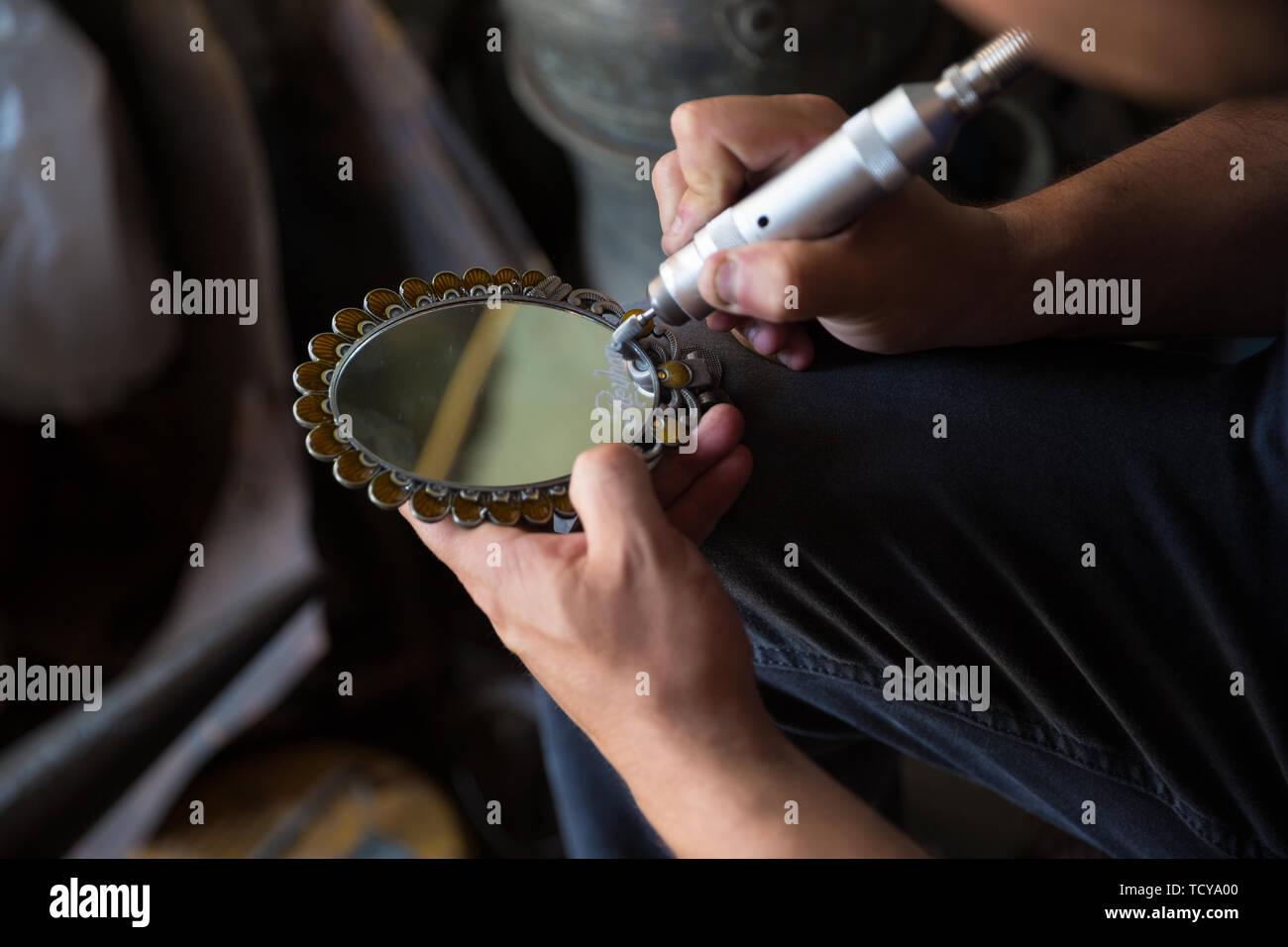 The master the special tool puts drawing on a mirror.Engraving on ...