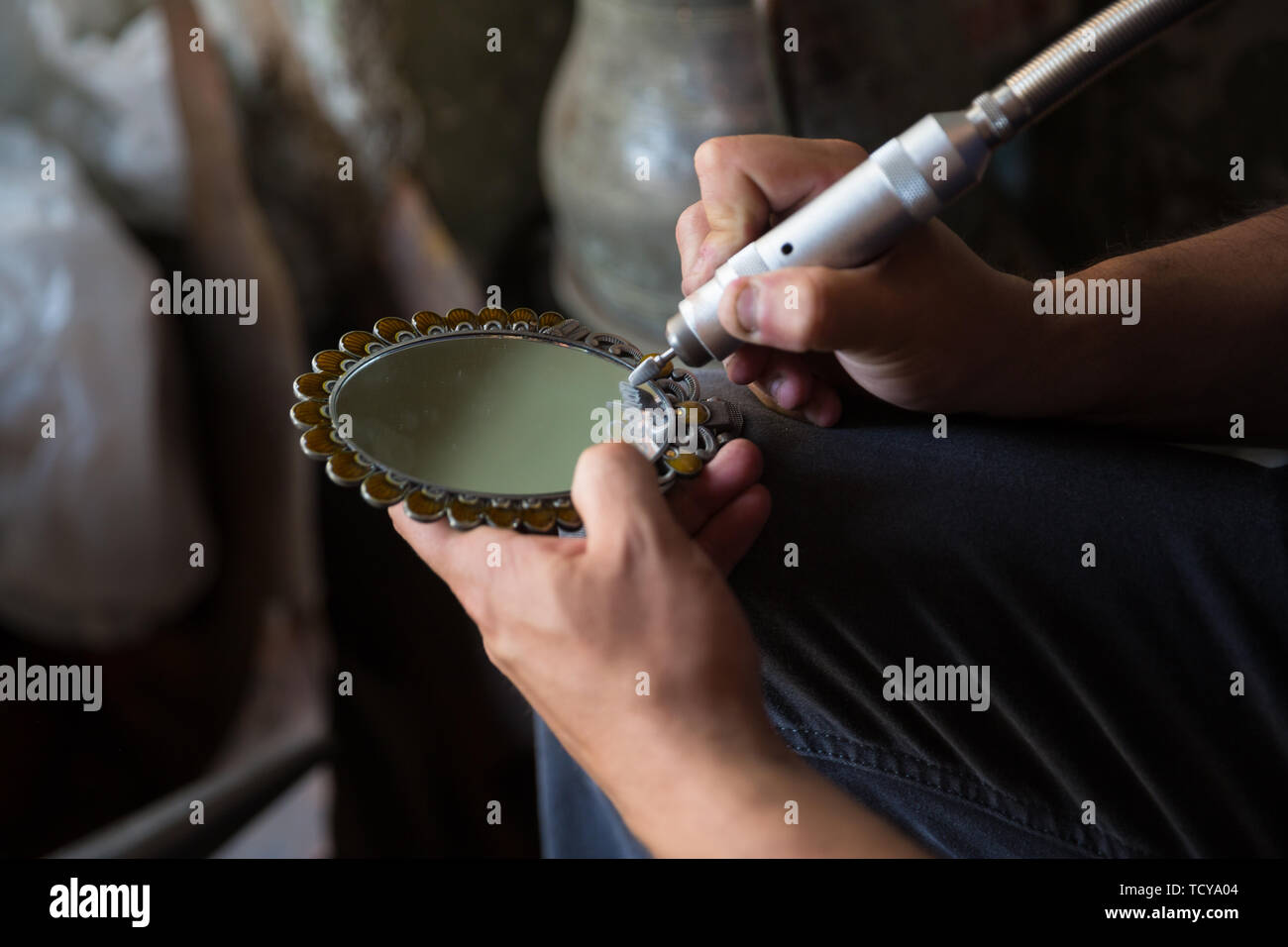 The master the special tool puts drawing on a mirror.Engraving on ...