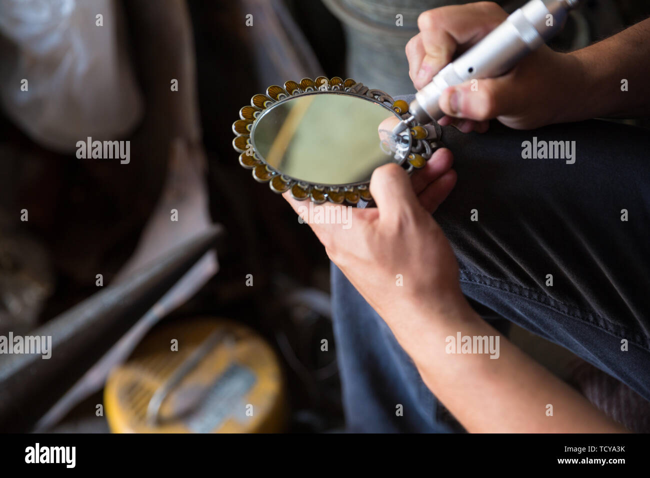 The master the special tool puts drawing on a mirror.Engraving on ...
