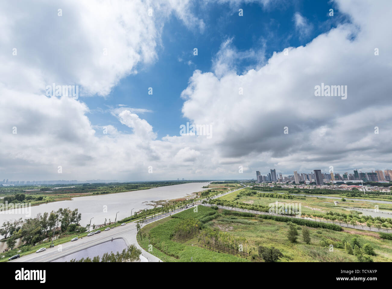 Cloudy weather overlooks riverside green space building Stock Photo - Alamy