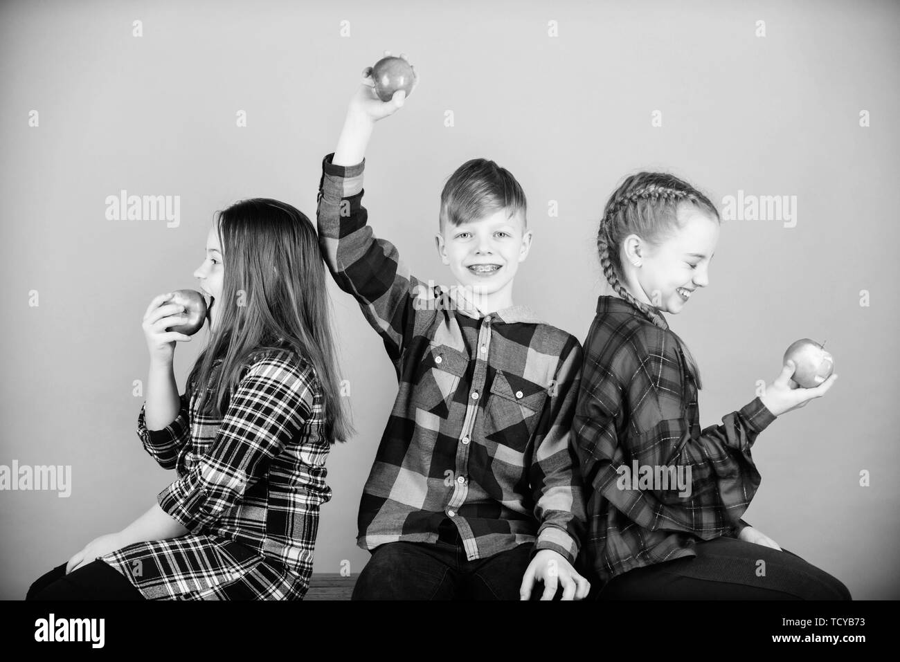 Healthy dieting and vitamin nutrition. Boy and girls friends eat apple ...