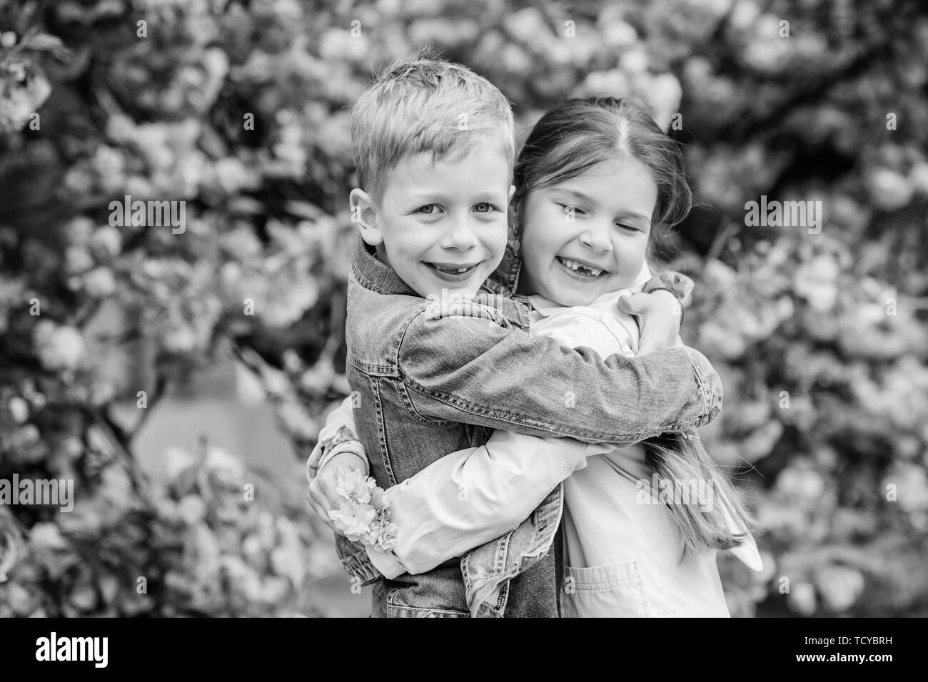 Love is in the air. Kids in love pink cherry blossom. Romantic babies ...