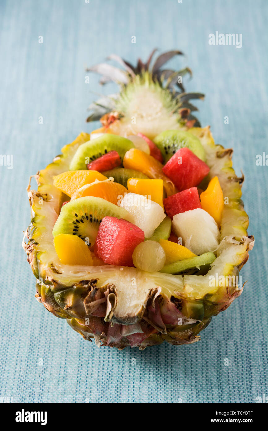 Mix fruit served inside pineapple on blue background Stock Photo - Alamy