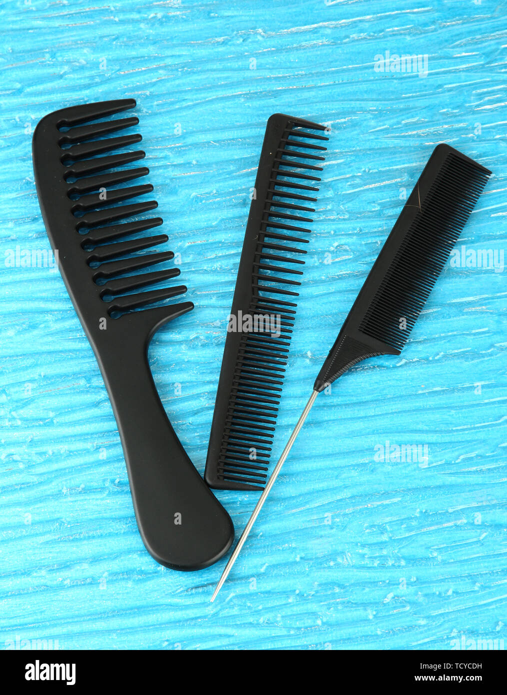 Black combs on color background Stock Photo - Alamy