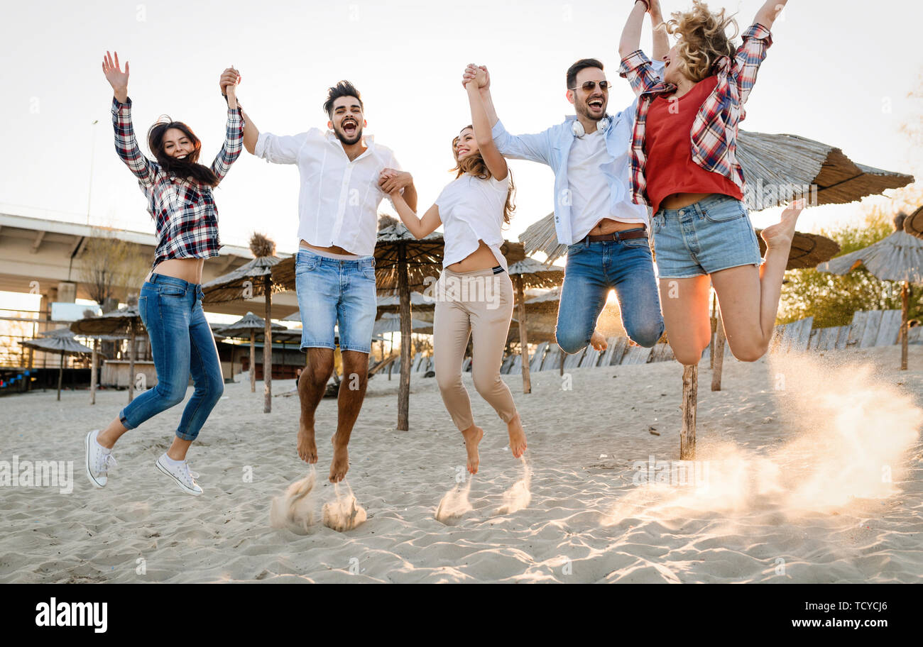 Group of happy friends partying on beach Stock Photo - Alamy