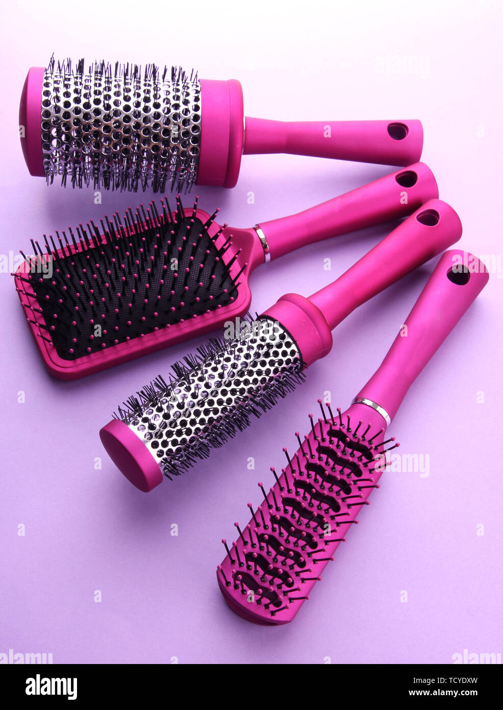 Comb brushes on purple background Stock Photo - Alamy