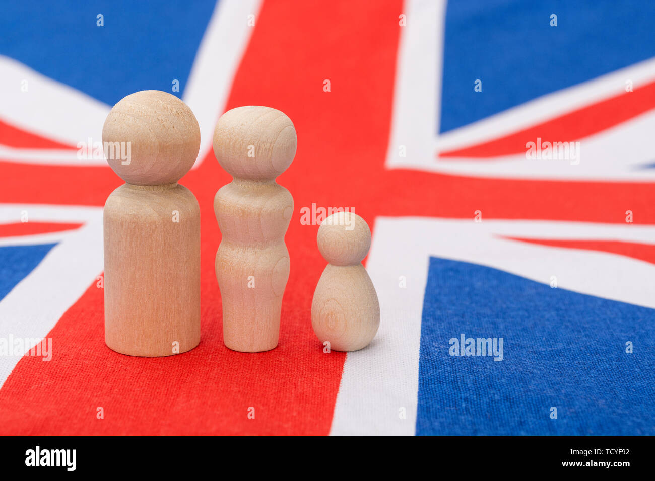 Small wooden abstract figures on Union Jack flag. For demographic of UK ...