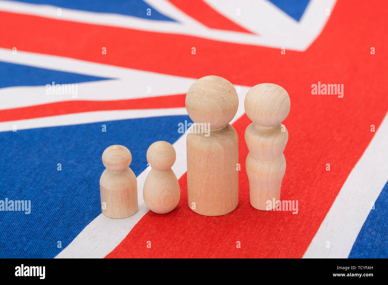 Small wooden abstract figures on Union Jack flag. For demographic of UK ...