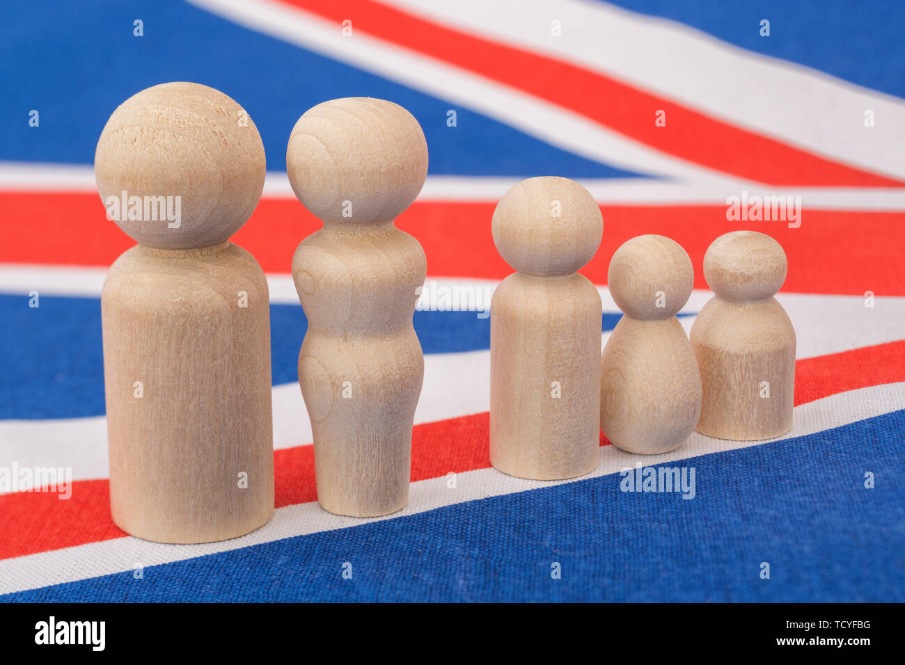Small wooden abstract figures on Union Jack flag. For demographic of UK ...