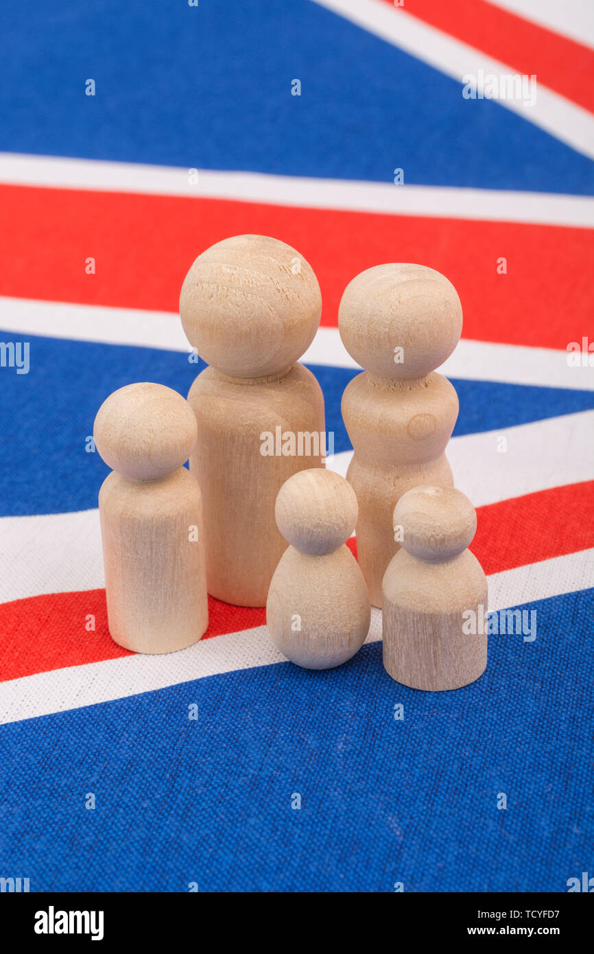 Small wooden abstract figures on Union Jack flag. For demographic of UK ...