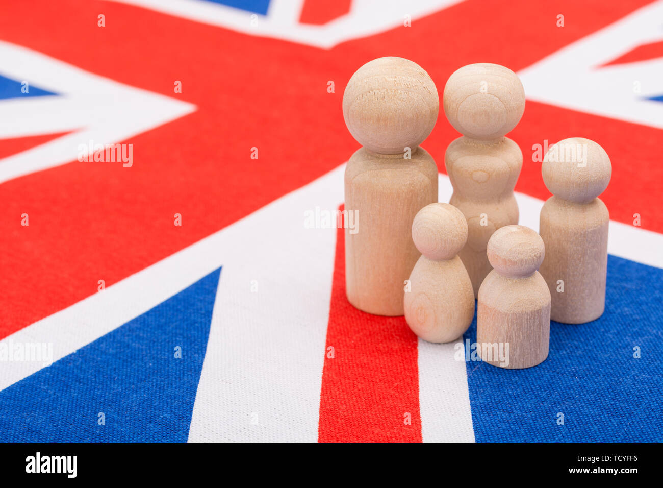 Small wooden abstract figures on Union Jack flag. For demographic of UK ...