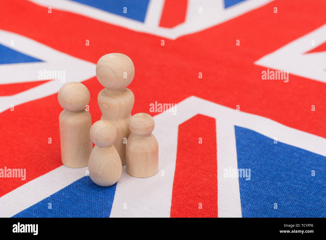 Small wooden abstract figures on Union Jack flag. For demographic of UK ...