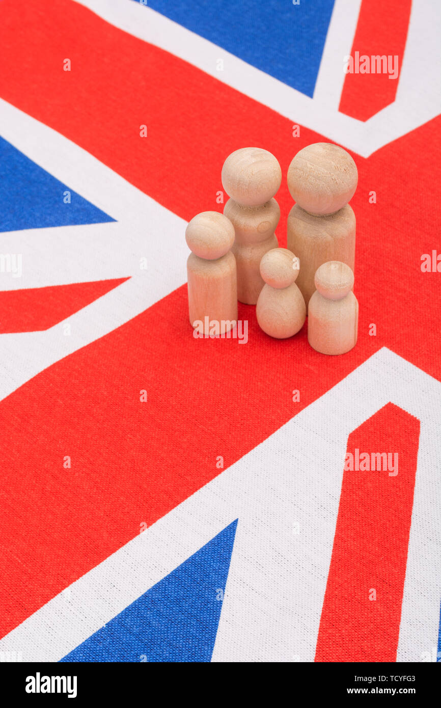 Small wooden abstract figures on Union Jack flag. For demographic of UK ...