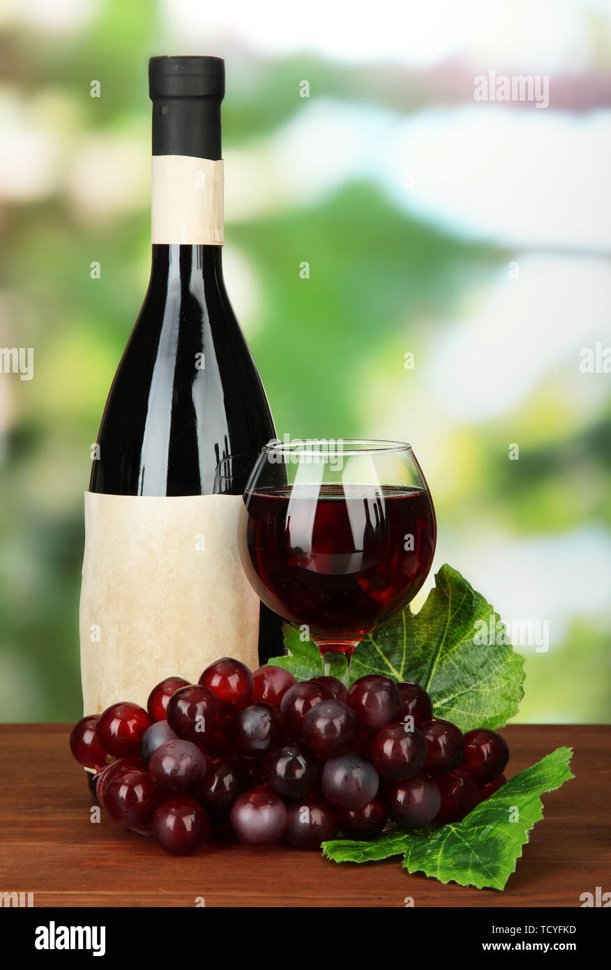 Composition of wine bottle, glass and grape, on bright background Stock ...