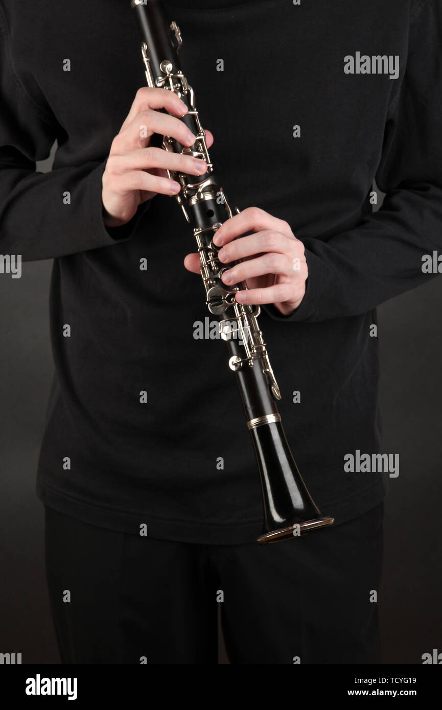 Musician playing on clarinet on black background Stock Photo - Alamy