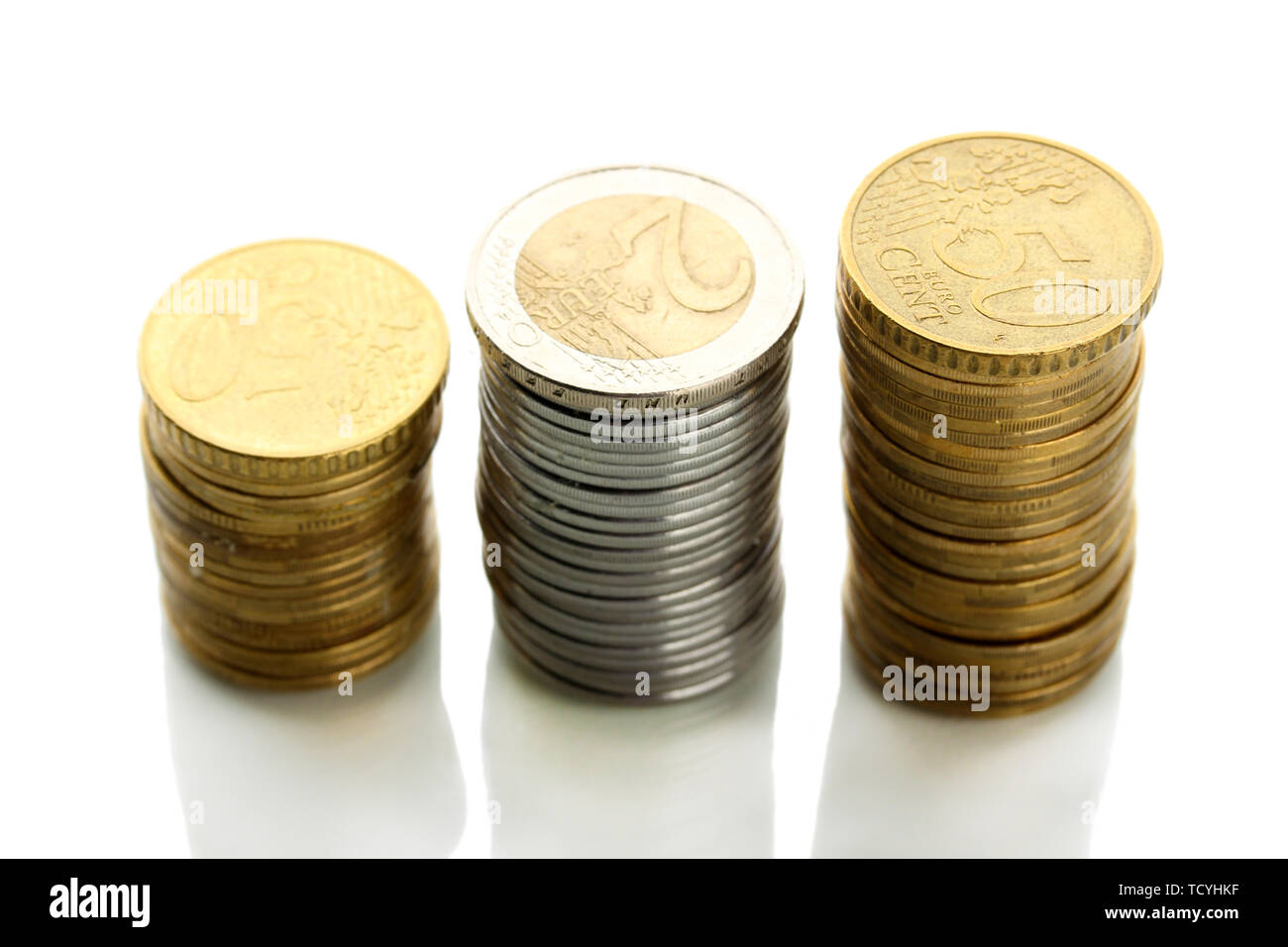 Many coins in columns isolated on white Stock Photo - Alamy