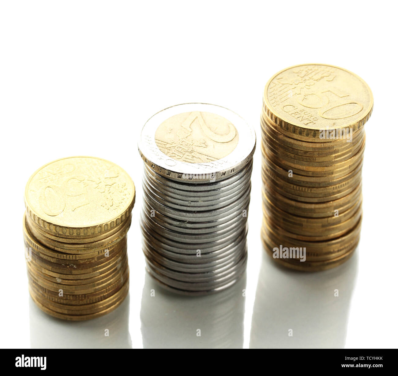 Many coins in columns isolated on white Stock Photo - Alamy