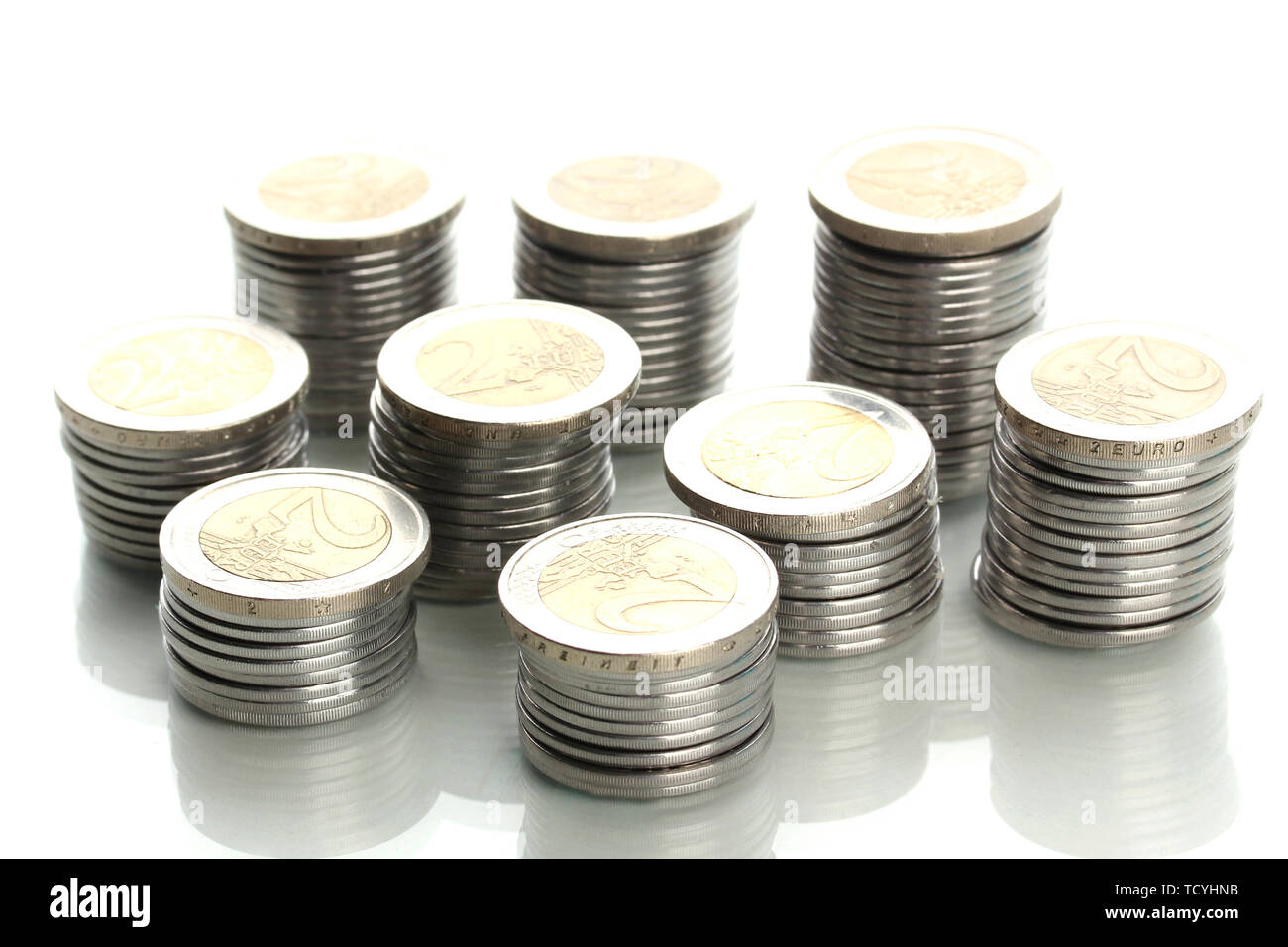 Many coins in columns isolated on white Stock Photo - Alamy