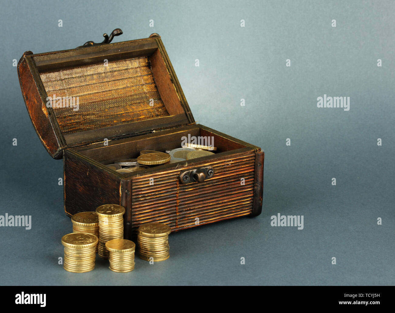Coins in chest on grey background Stock Photo - Alamy
