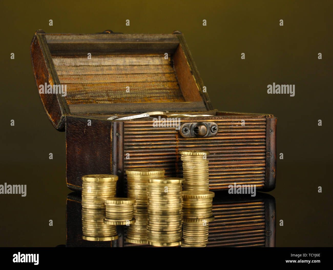 Coins in chest on dark background Stock Photo - Alamy