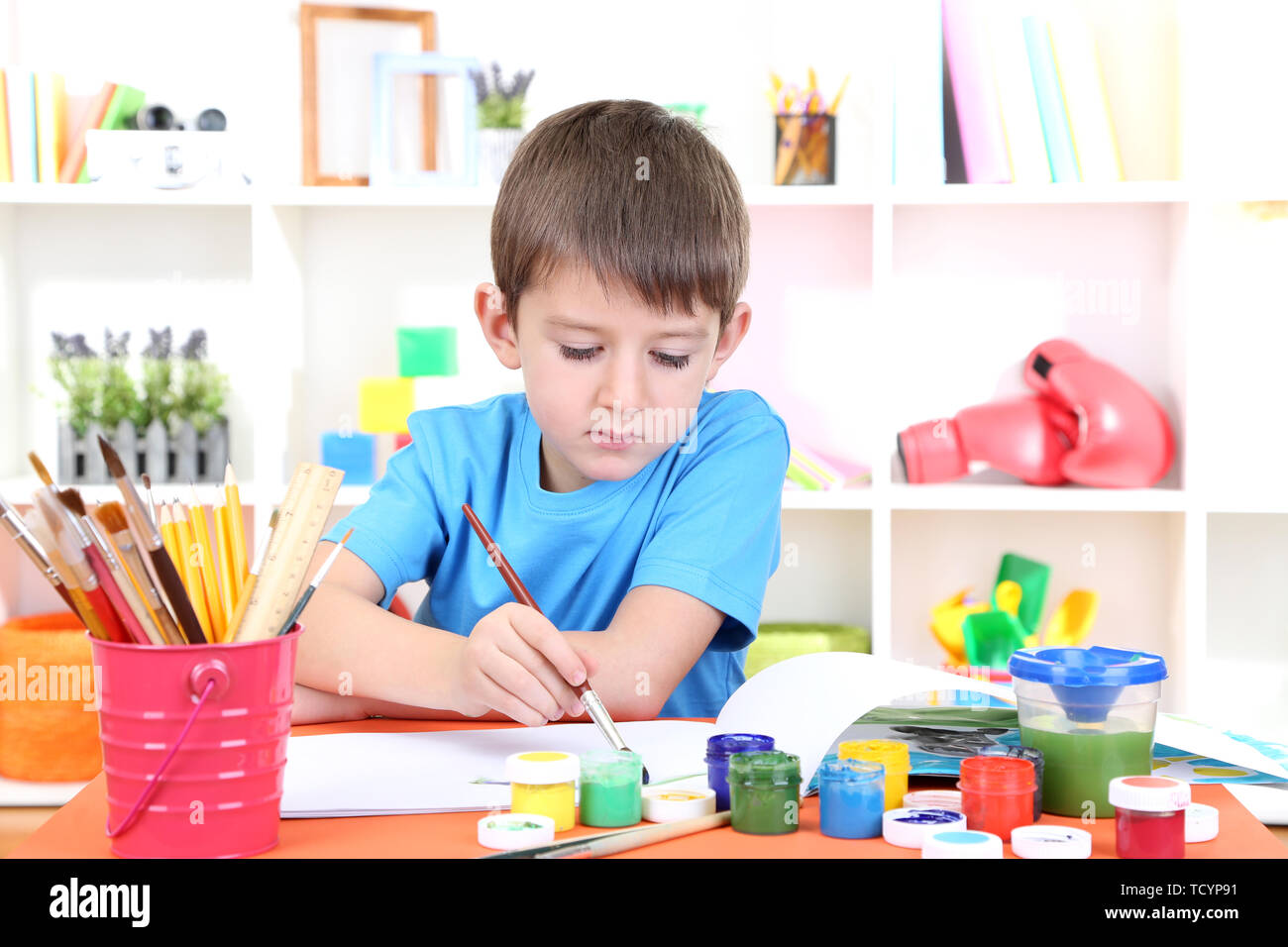 Cute little boy painting in his album Stock Photo - Alamy