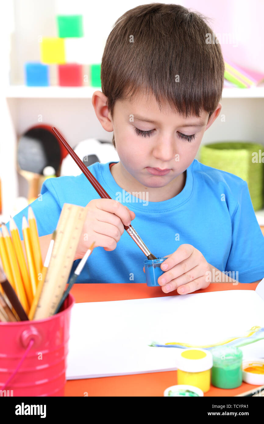 Cute little boy painting in his album Stock Photo - Alamy