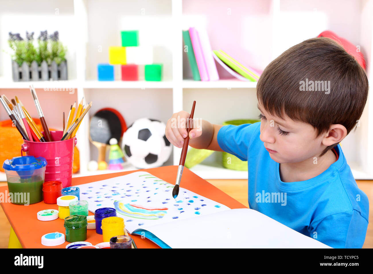 Cute little boy painting in his notebook Stock Photo - Alamy