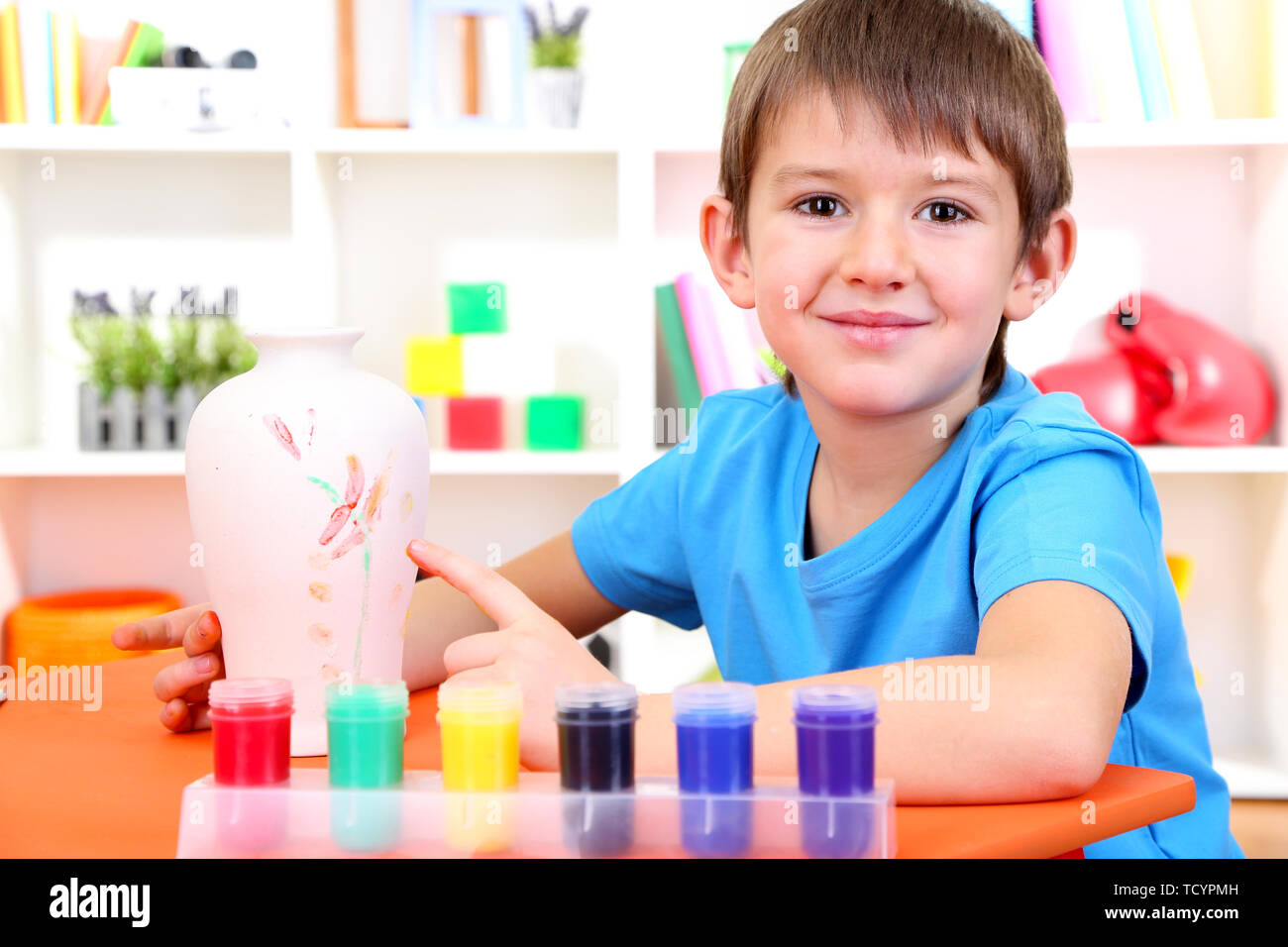 Cute little boy painting clay vase Stock Photo - Alamy