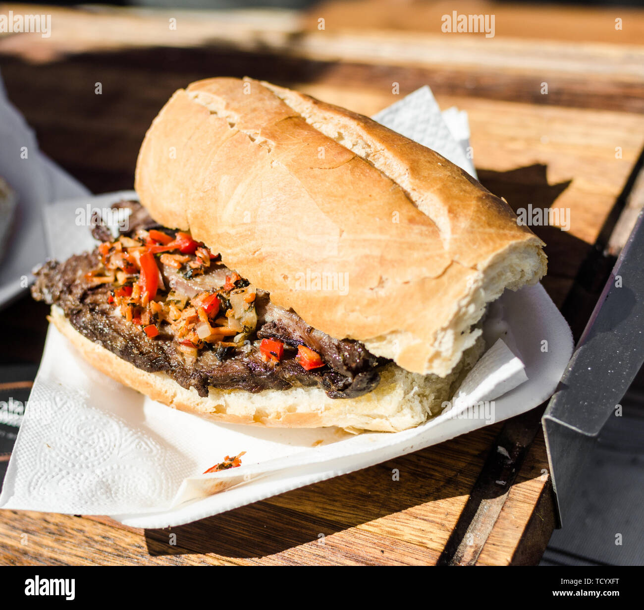 Sandwich with llama meat and criolla sauce at a street food market ...