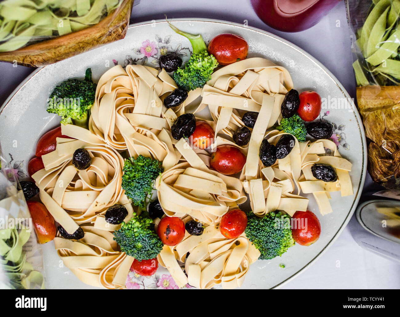 Serving example of pasta with broccoli, olives, and cherry tomatoes ...