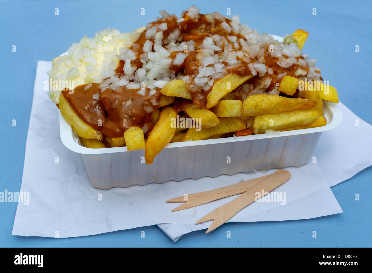 Traditional Dutch fast food dish, fried potatoes with sate sauce, onion ...