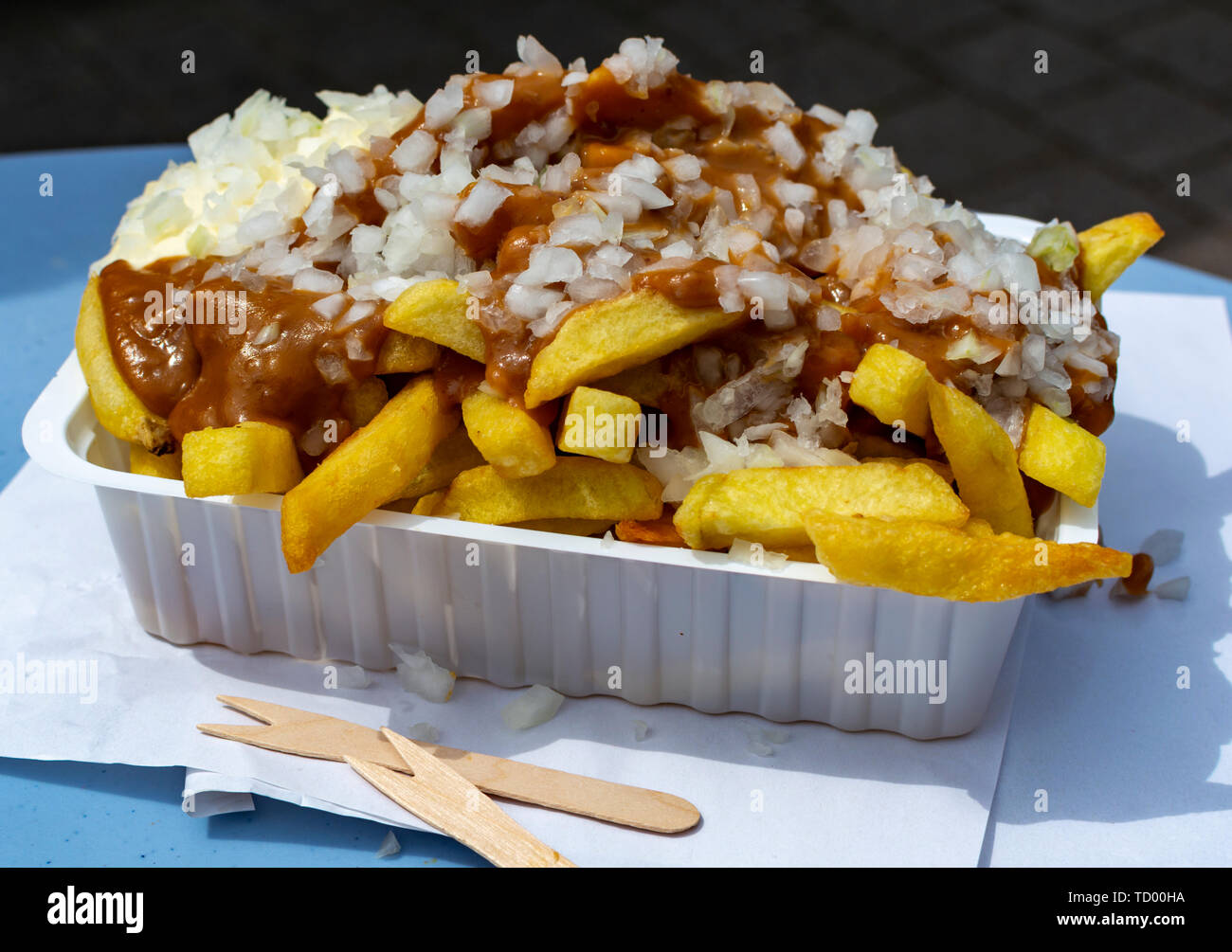 Traditional Dutch fast food dish, fried potatoes with sate sauce, onion ...