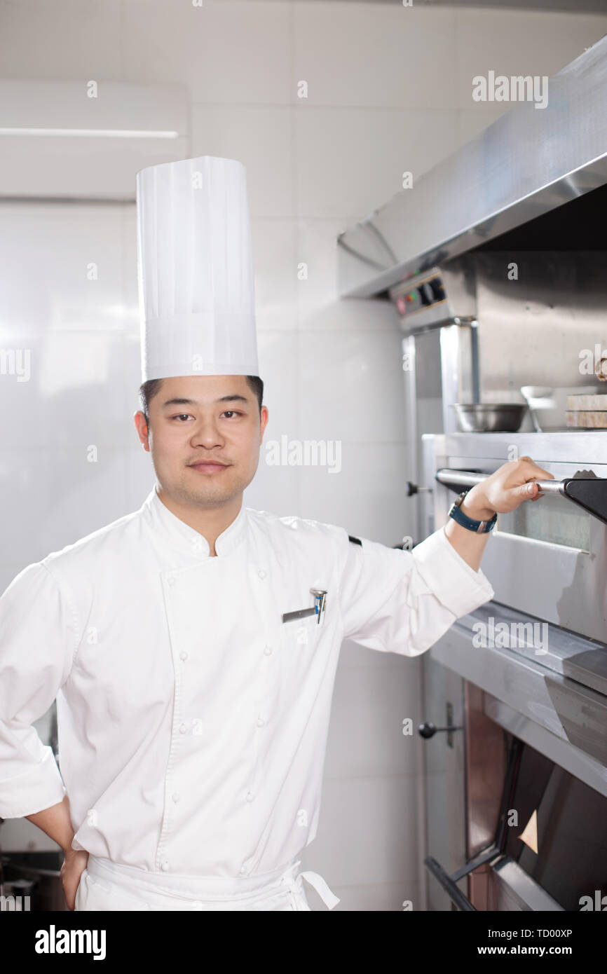 young chinese man chelf in modern kitchen Stock Photo - Alamy