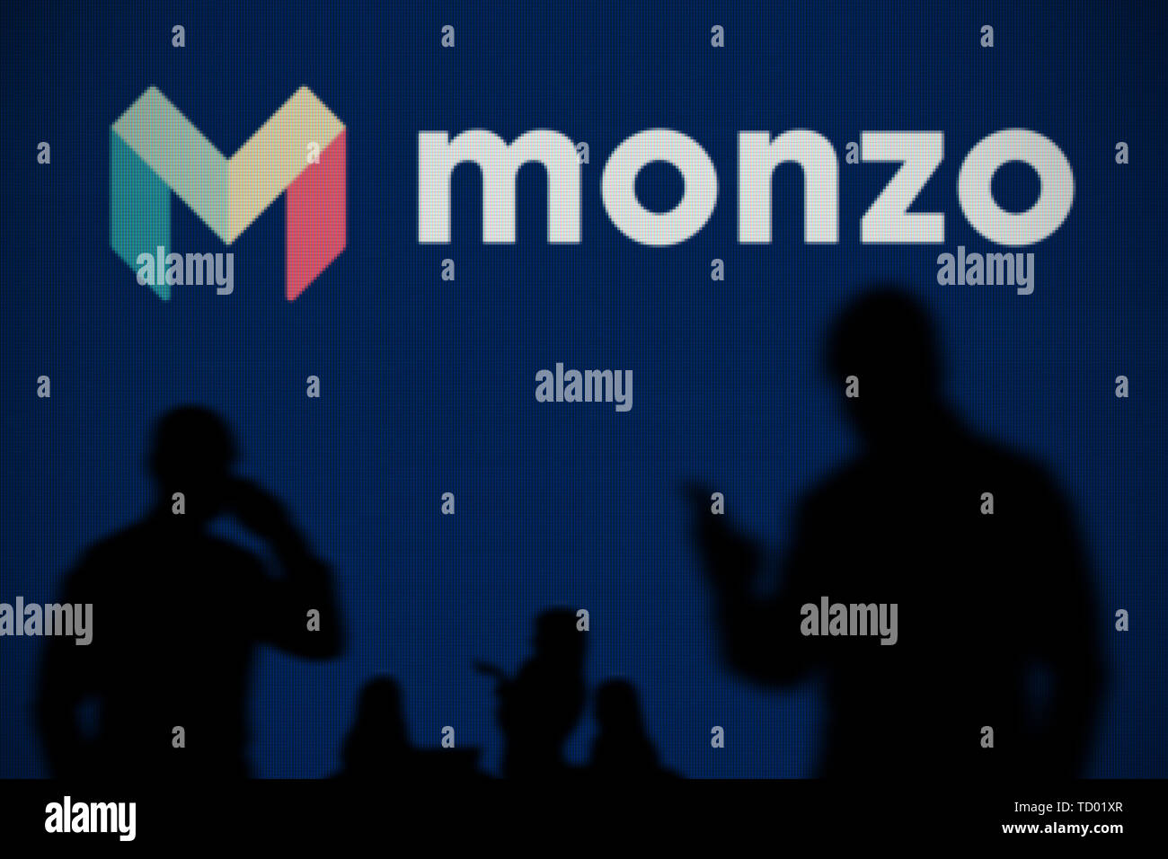 The Monzo bank logo is seen on an LED screen in the background while a ...
