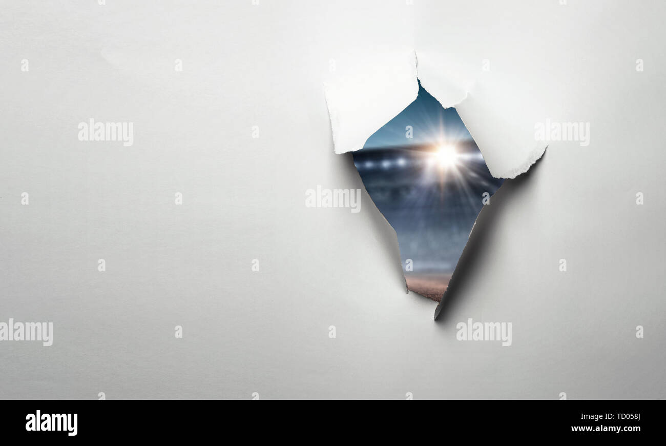 Paper torn hole effect with stadium view Stock Photo - Alamy