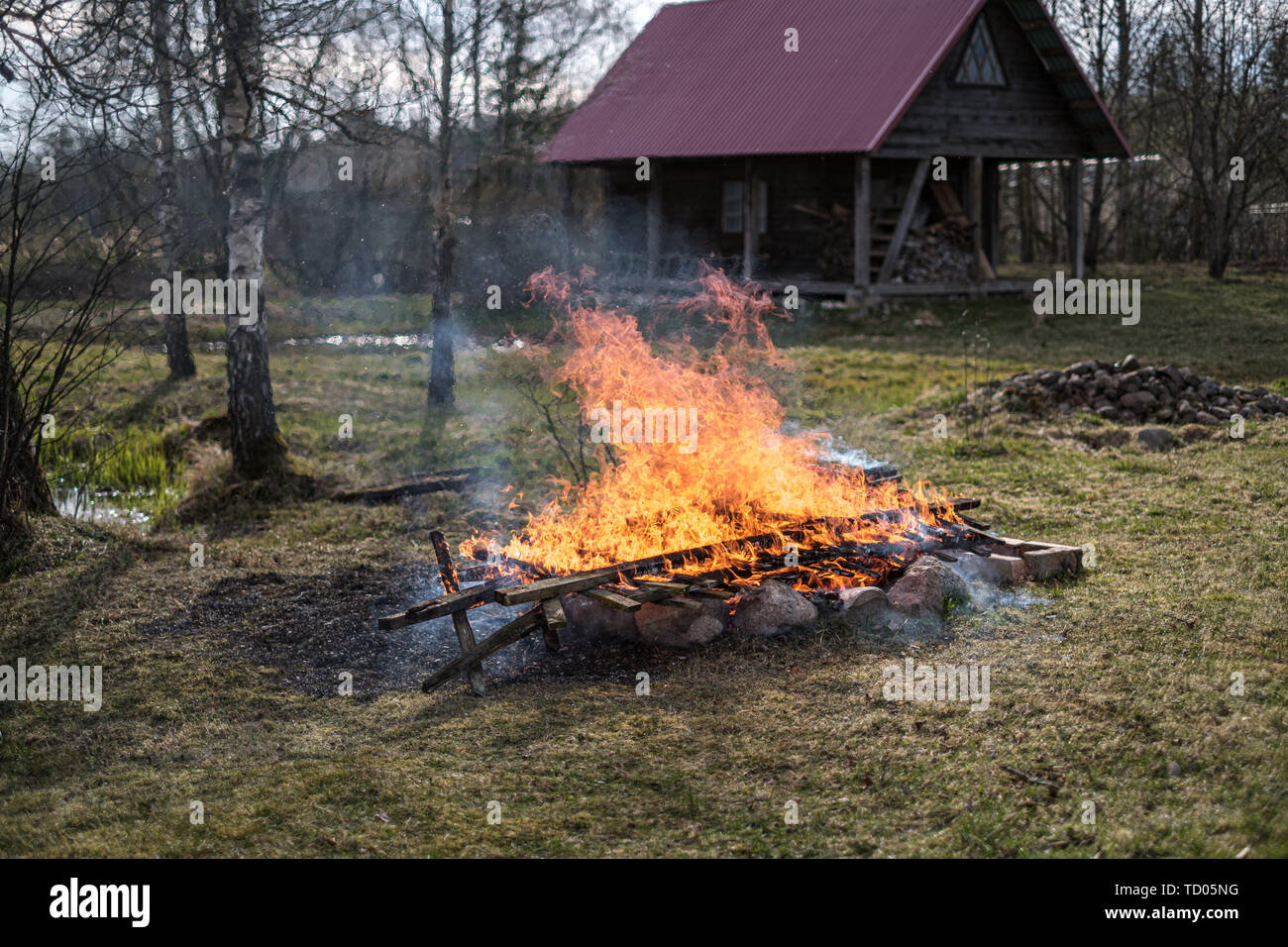 open fire burning in countryside home garden. controlled pyromaniac ...