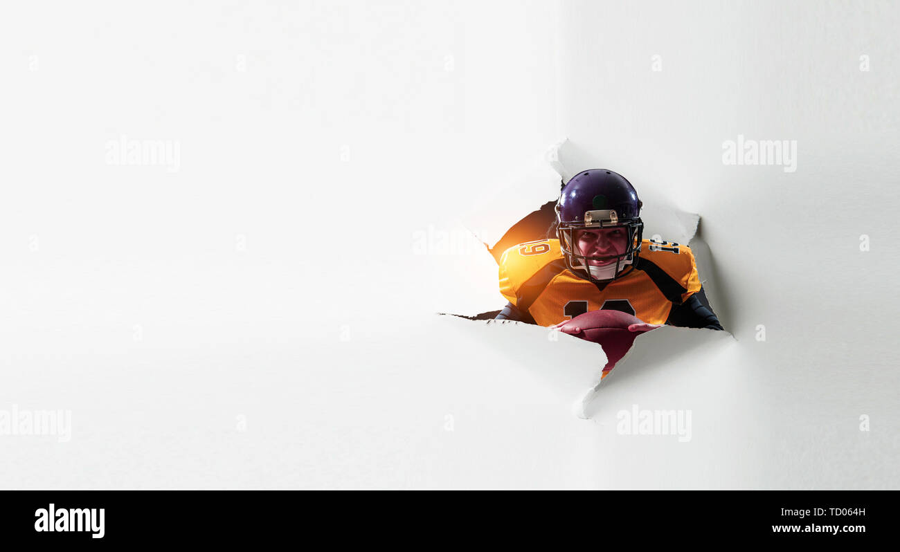 Paper breakthrough hole effect and american football Stock Photo - Alamy