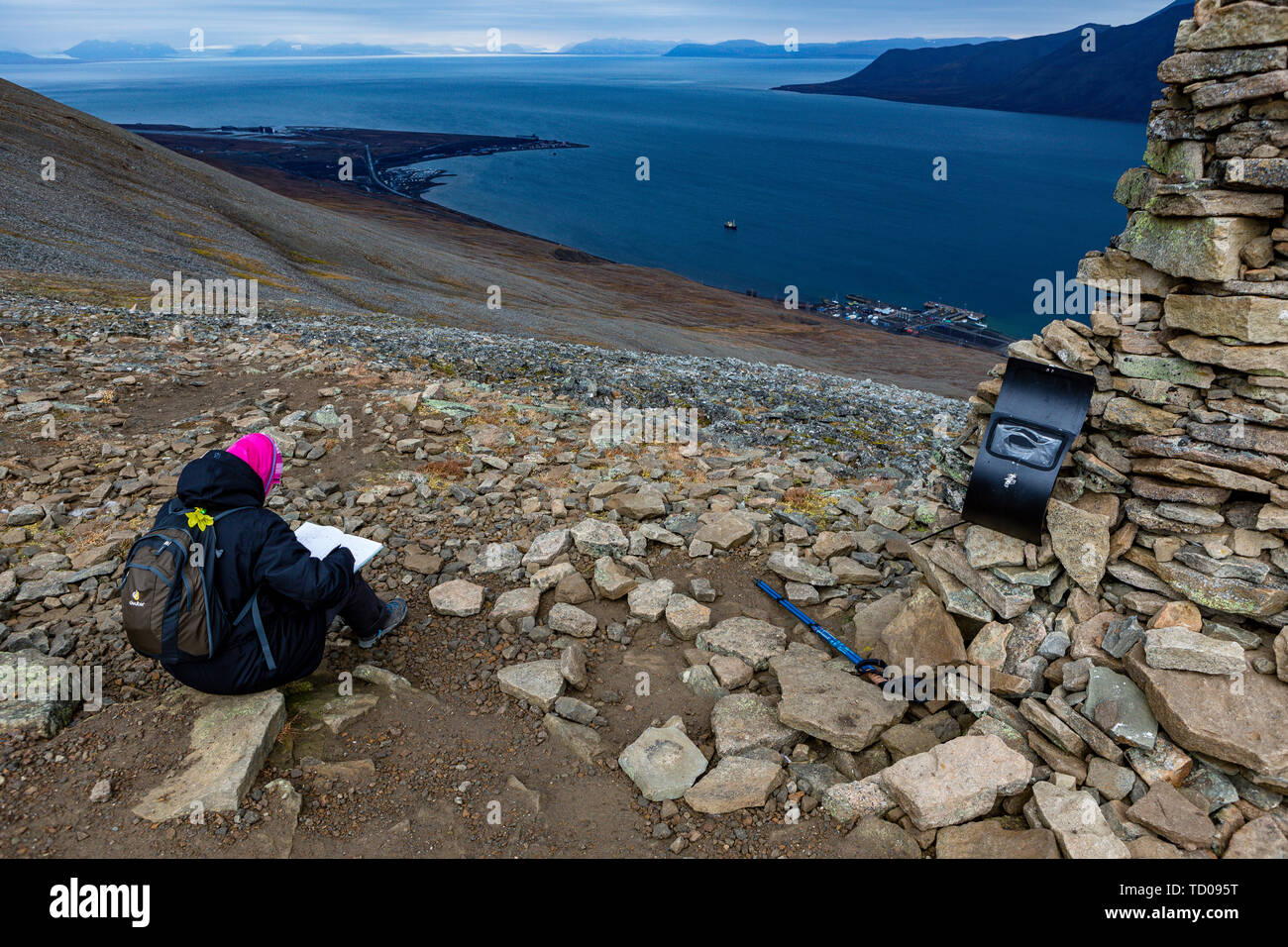 hiking woman write note into mountains log book, Svalbard mountain ...