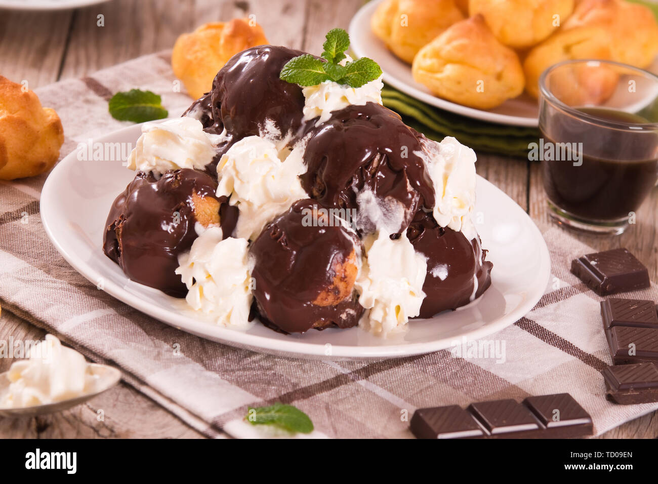 Chocolate profiteroles with chantilly cream hi-res stock photography ...