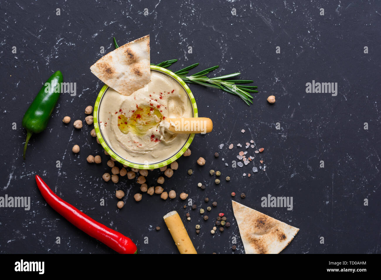Homemade hummus with pita and grissini bread sticks, chilli, jalapeno ...