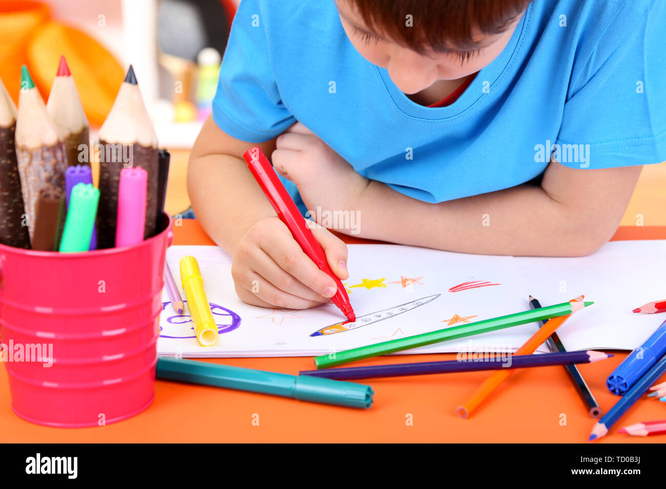 Cute little boy drawing in his notebook Stock Photo - Alamy