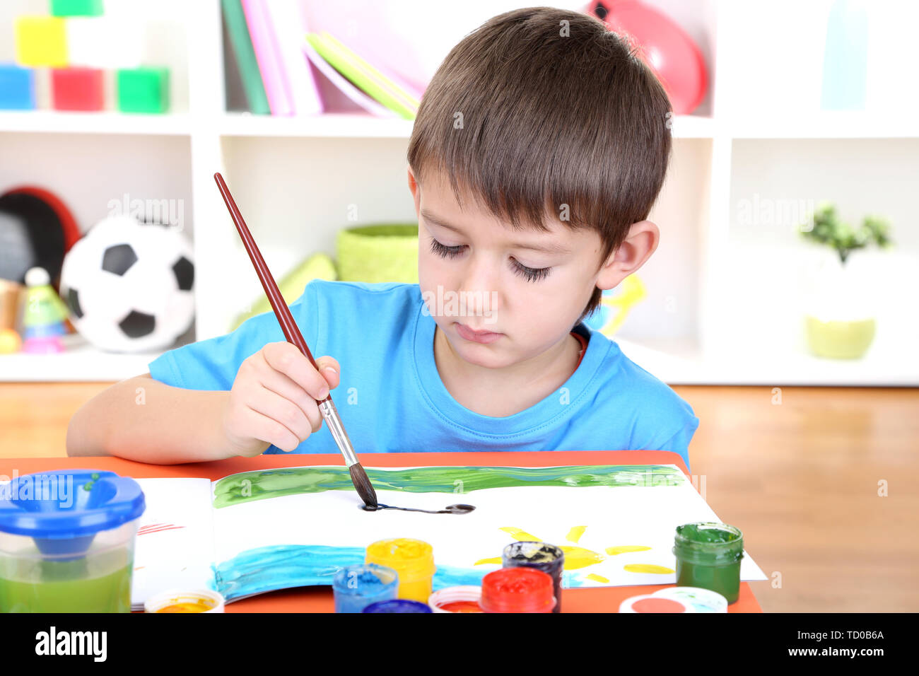 Cute little boy painting in his album Stock Photo - Alamy