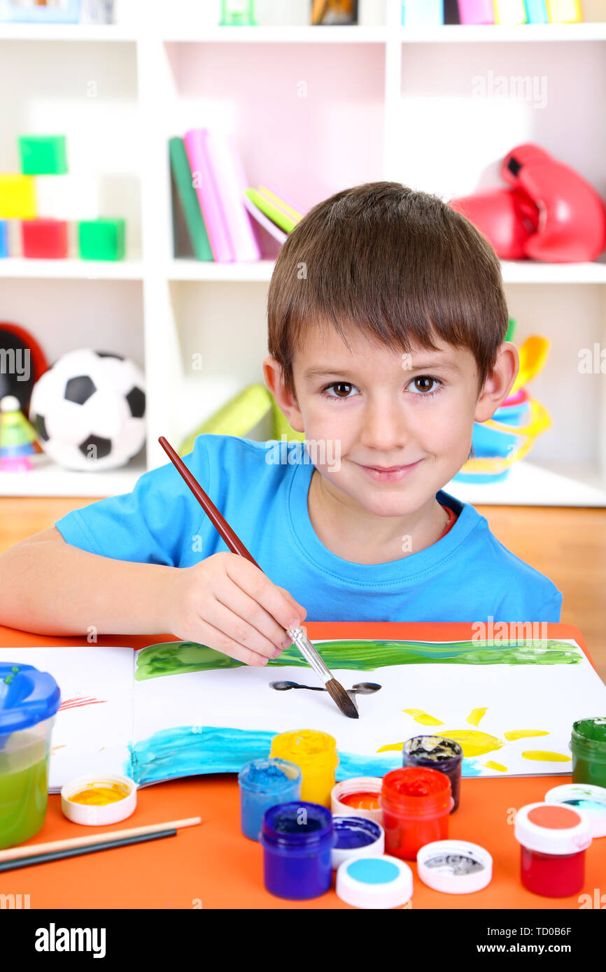 Cute little boy painting in his album Stock Photo - Alamy