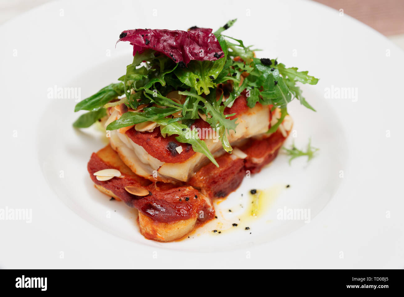 Fish and potatoes fried with romesco sauce, close-up Stock Photo - Alamy