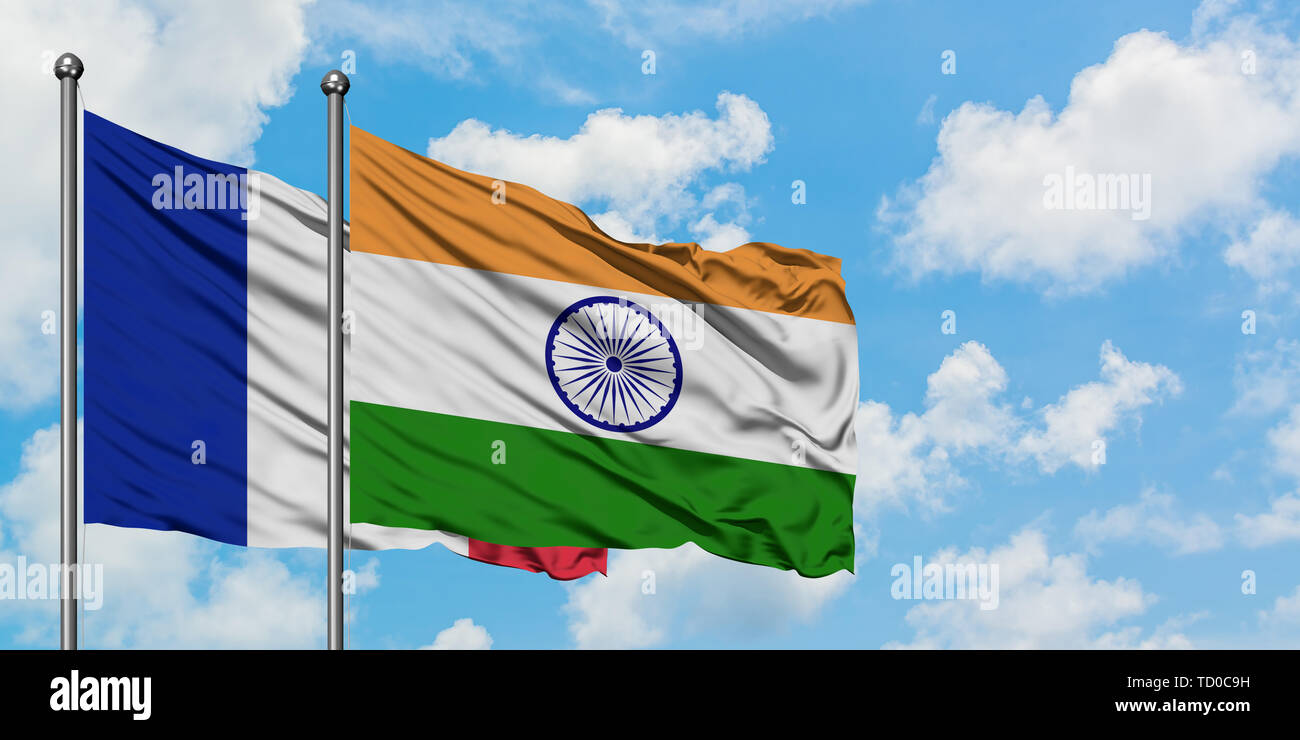 France and India flag waving in the wind against white cloudy blue sky ...